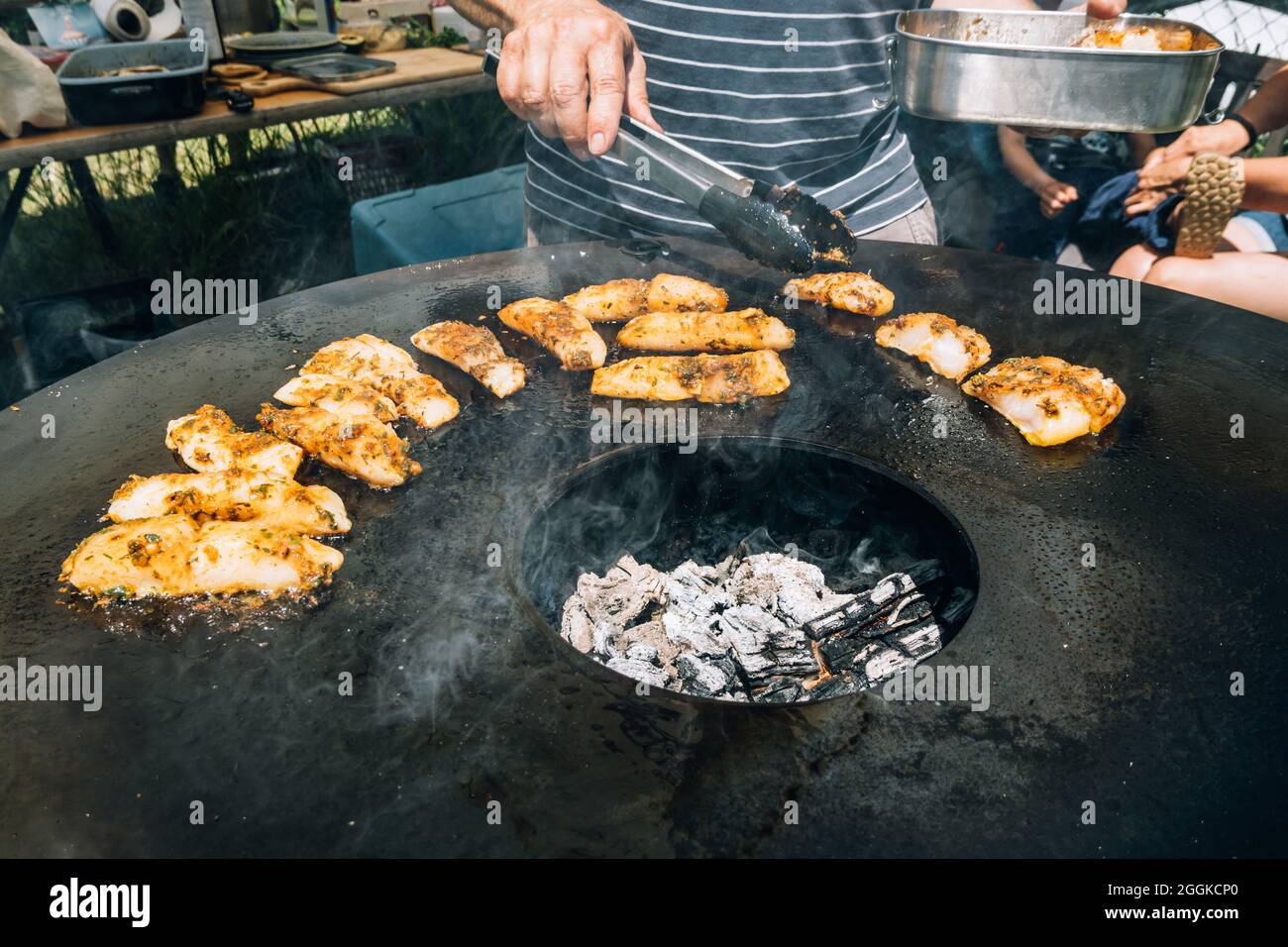 Frying herbed fish filets on a plancha barbeque grill Stock Photo - Alamy