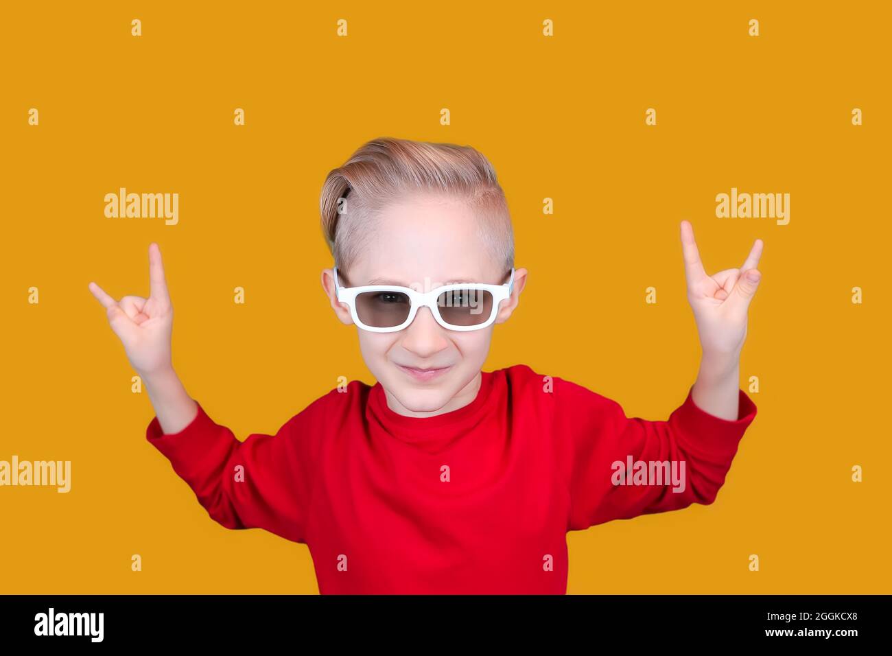 a cool and cheerful child in red clothes and glasses shows hand ...