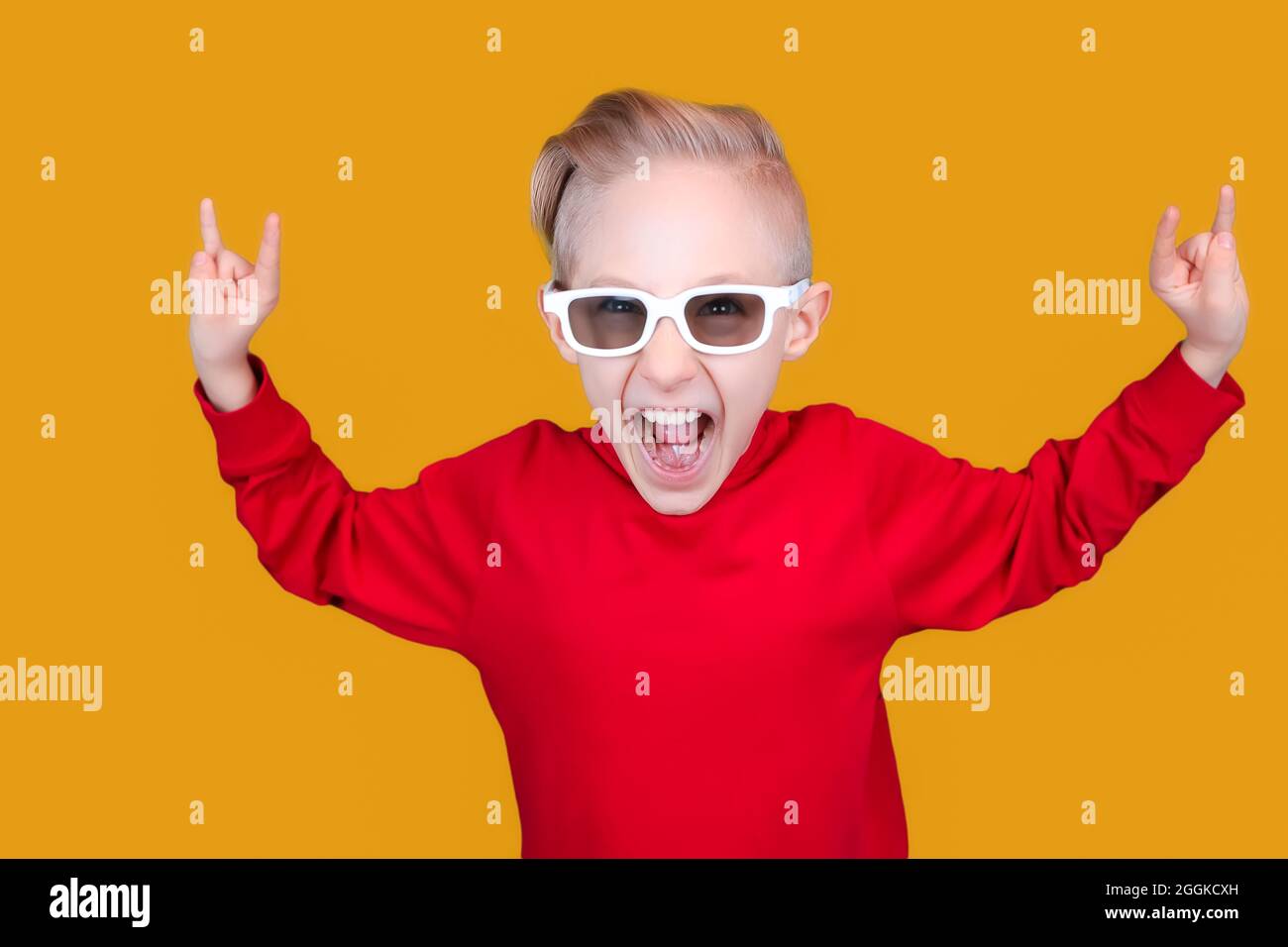 a cool and cheerful child in red clothes and glasses shows hand ...