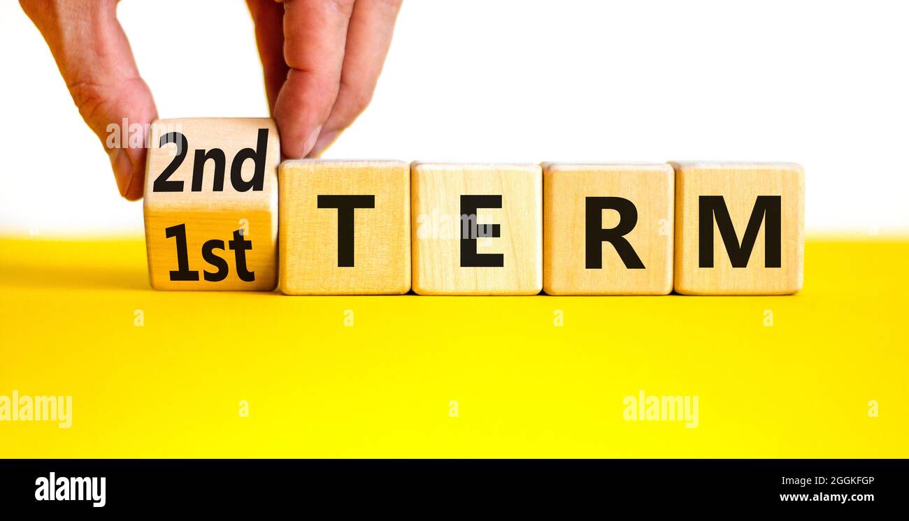 First or second term symbol. Businessman turns a cube and changes words ...