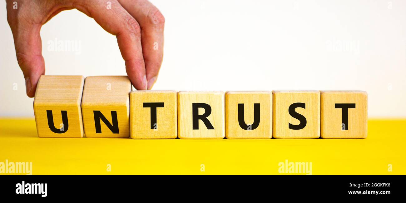 Untrust or trust symbol. Businessman turns wooden cubes, changes words ...