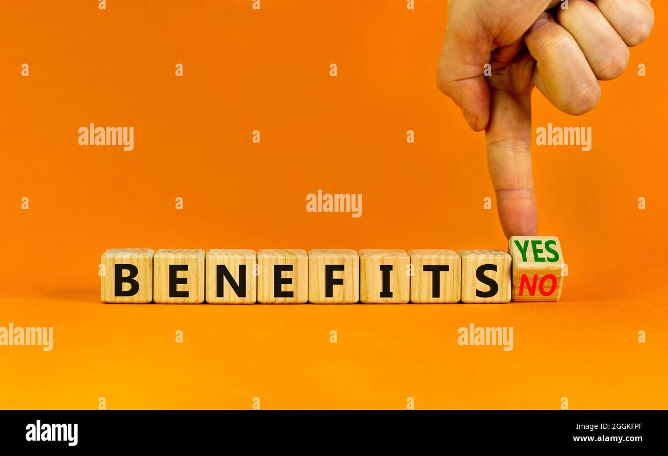 Benefits symbol. Businessman turns a wooden cube and change words ...
