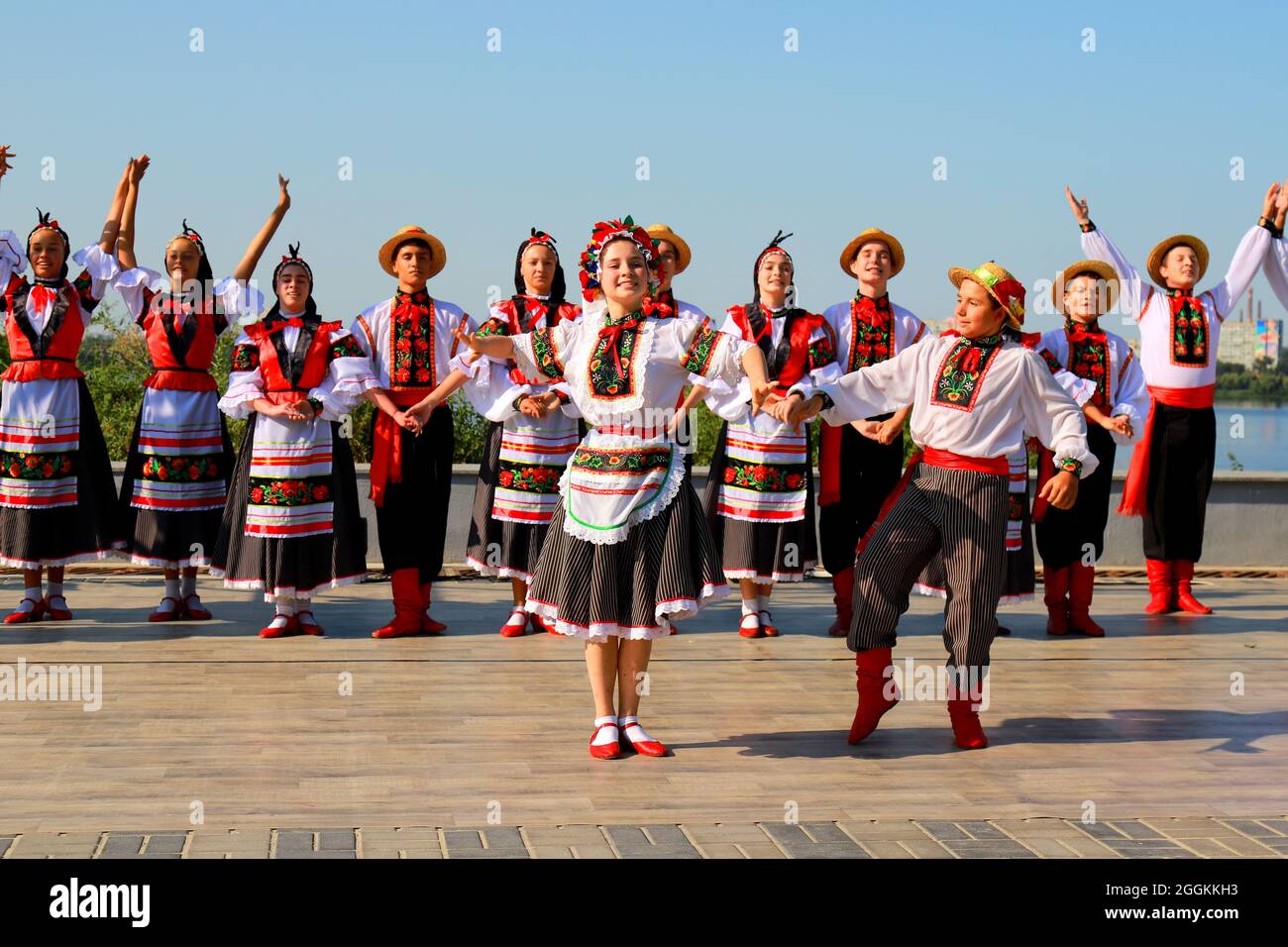 Young girls and boys dancing national Ukrainian dance in folk costumes ...