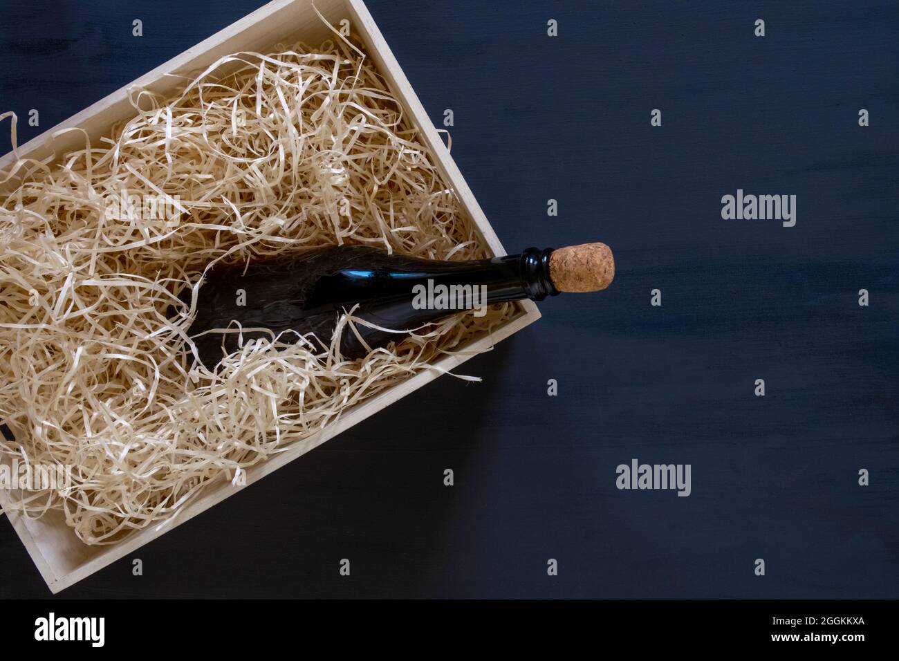 Straw into storage box with bottle of wine on the blue wooden ...