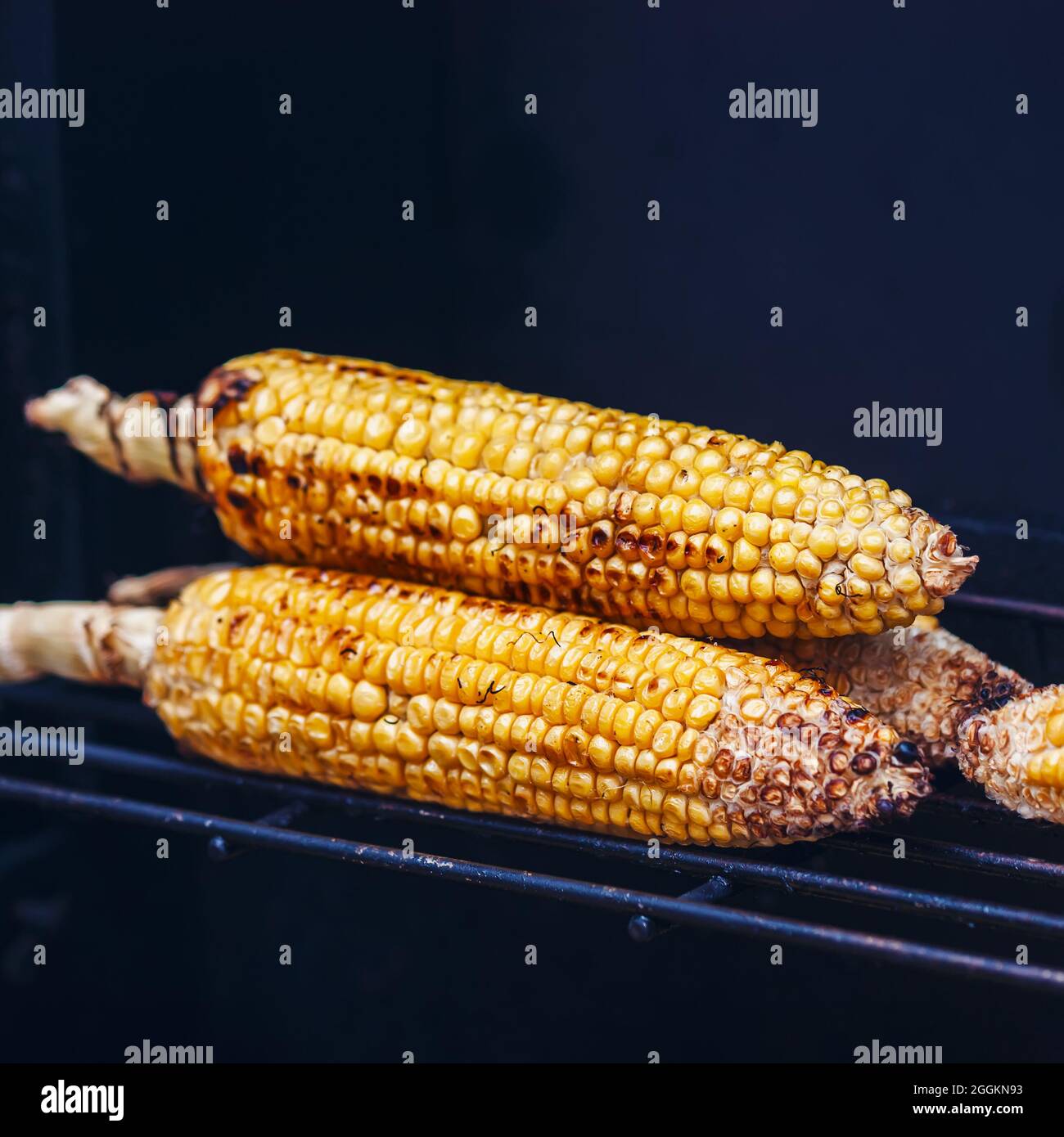 Grilled corn on metal grill close-up. Fast food. Food cooking outdoors ...