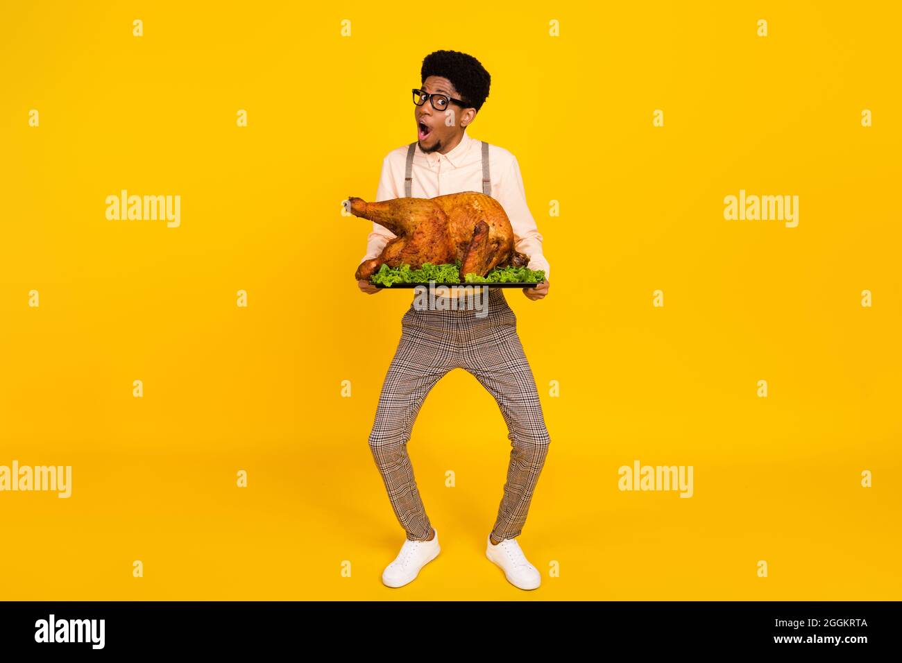 Full length body size photo man amazed funny keeping baked chicken ...