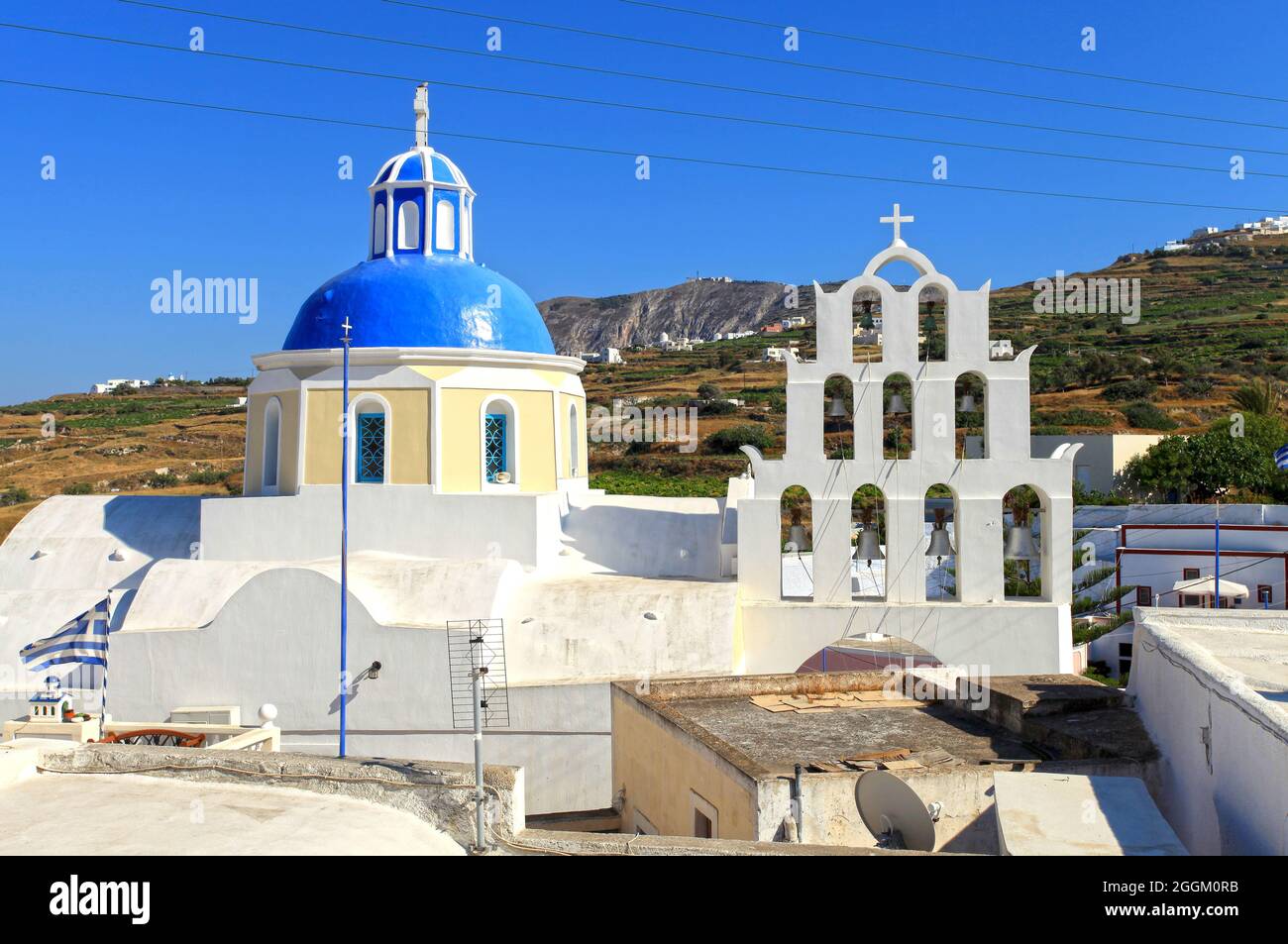 A Greek blue domed church with bell tower arch in the village of ...