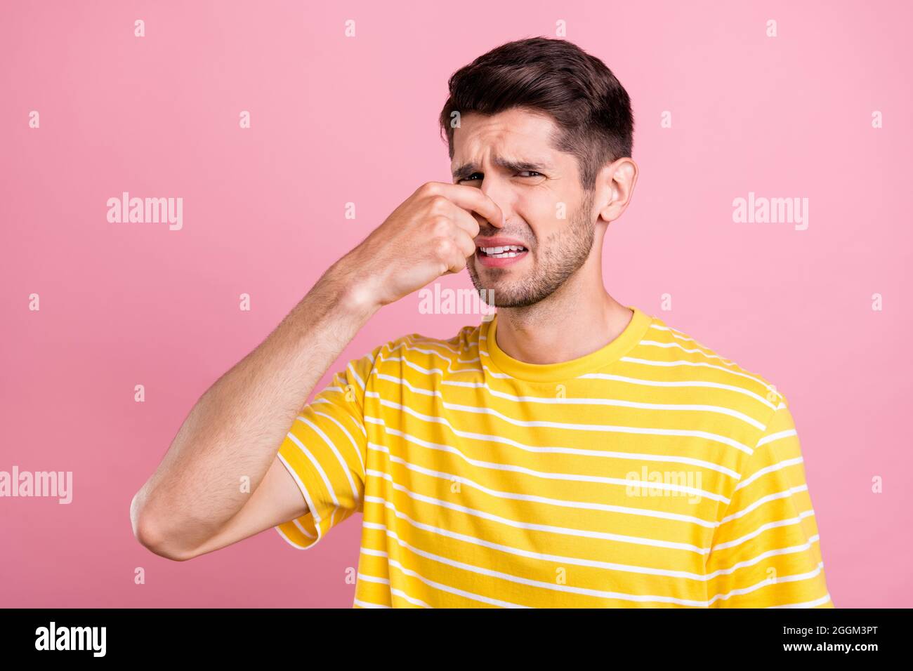 Portrait of attractive depressed gloomy moody guy closing nose bad ...