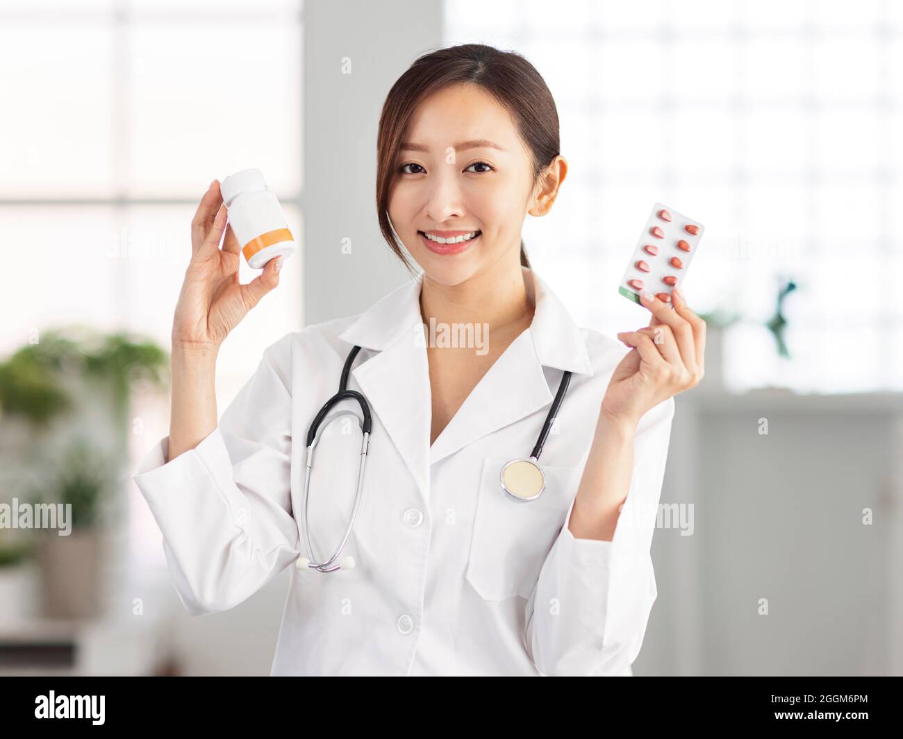 Smiling female doctor showing pills Stock Photo - Alamy