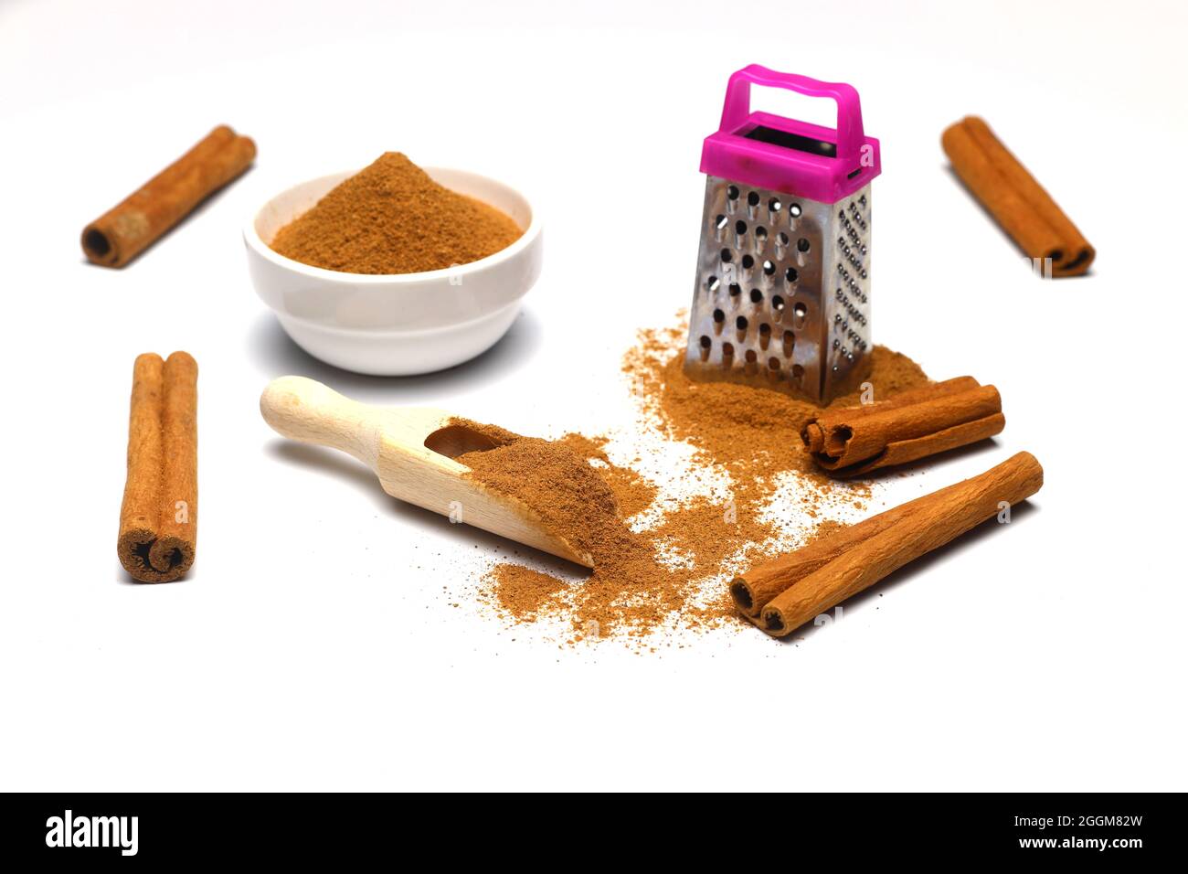 Cinnamon sticks and grater on white background Stock Photo - Alamy