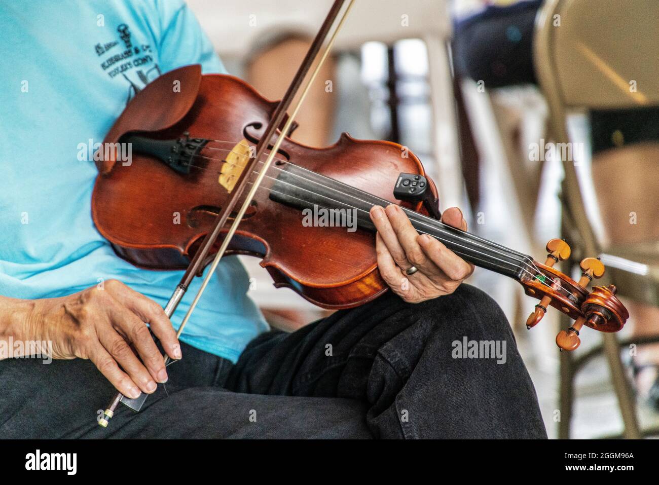 A senior lady plays the fiddle in the Mid-Day Mountain Music bluegrass ...