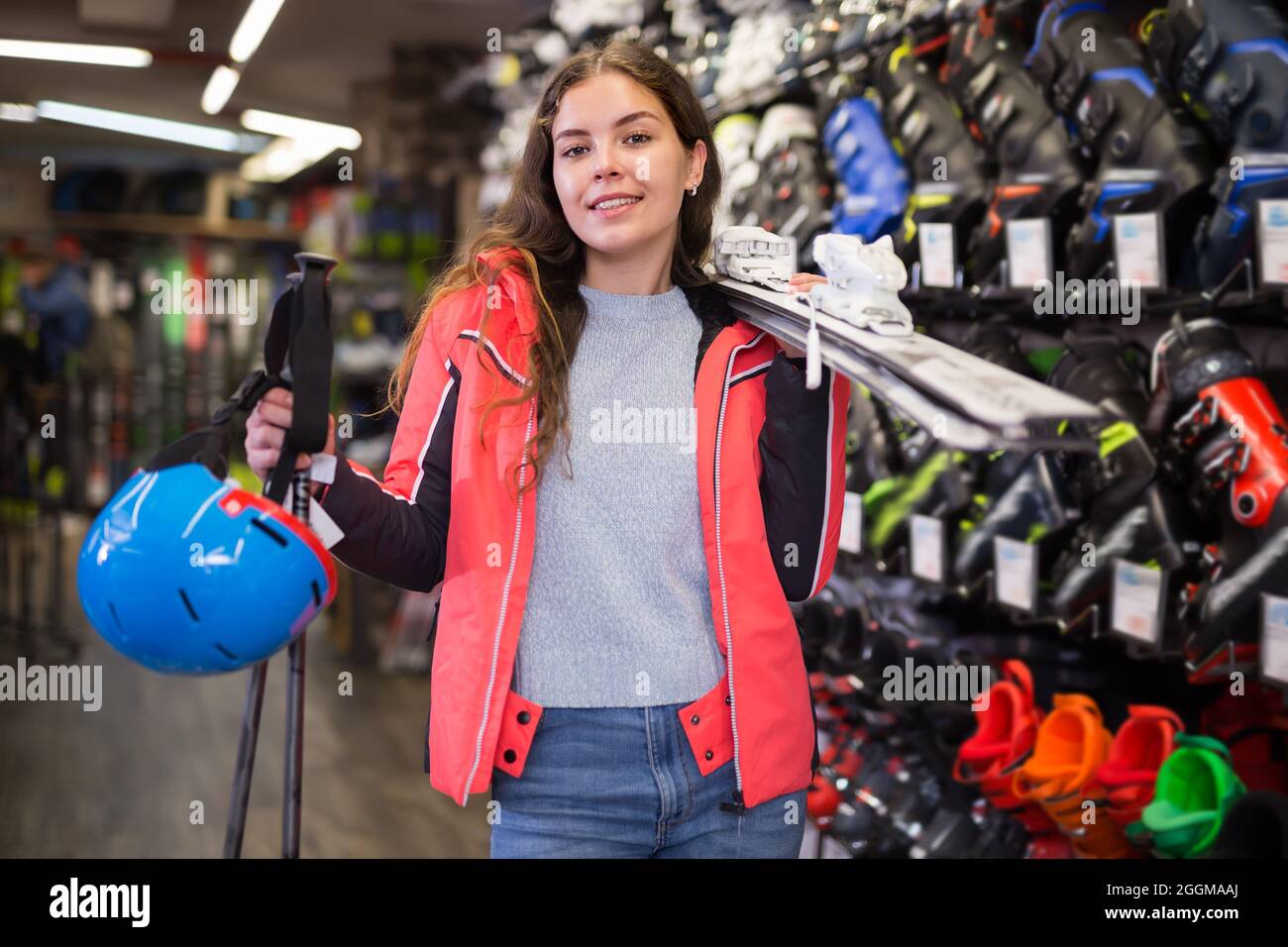 Smiling young girl chose skis, shelm and boots Stock Photo - Alamy