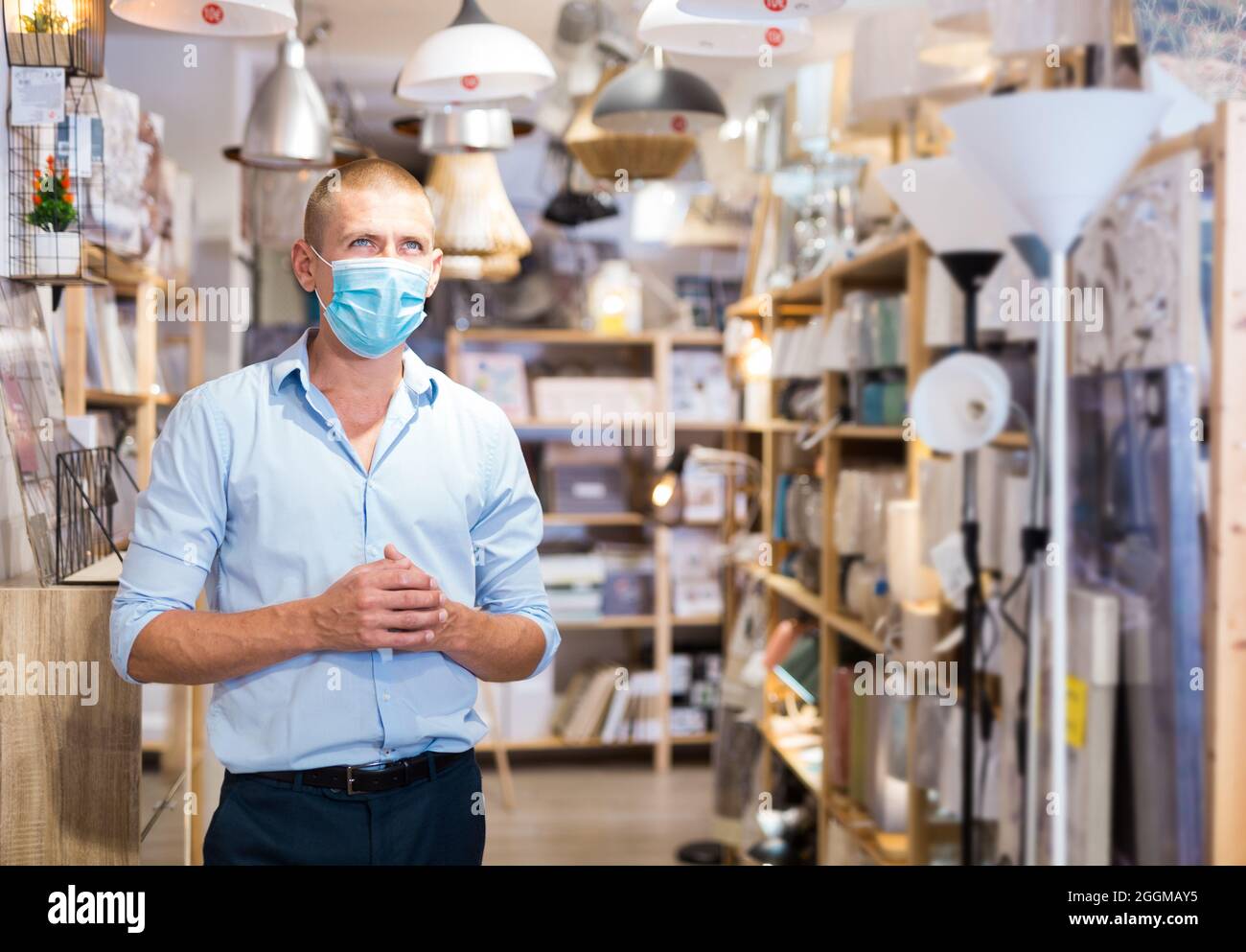 Man in mask choosing ceiling lamp Stock Photo - Alamy