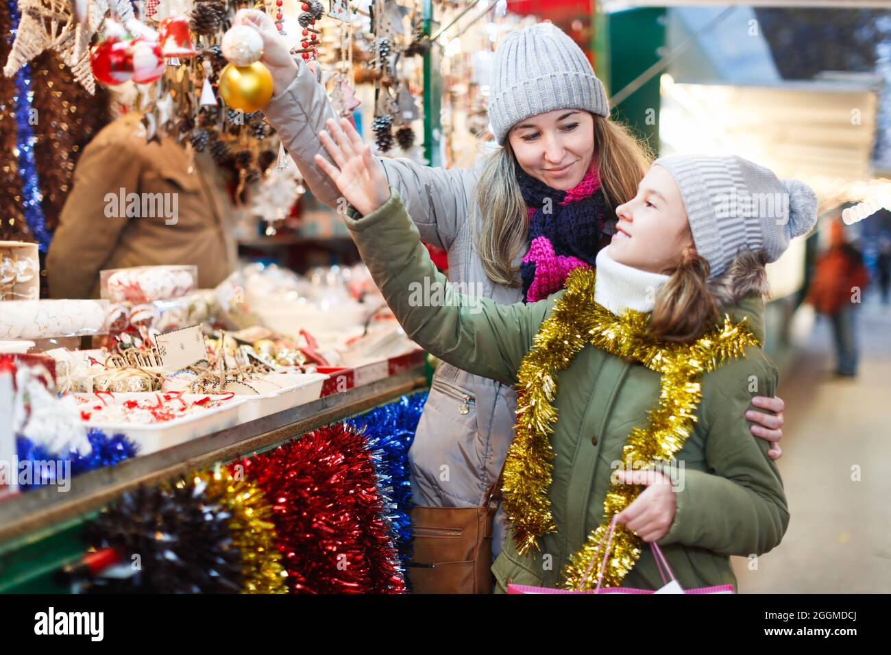 Girl with woman choosing balls on the tree Stock Photo - Alamy
