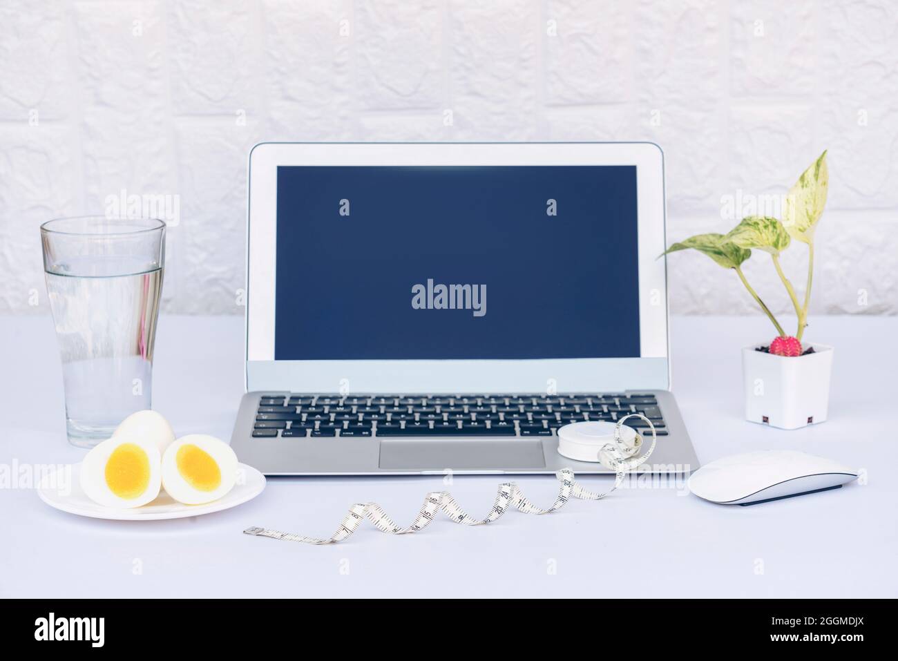 Glass of mineral water with boiled eggs and laptop computer isolated on ...