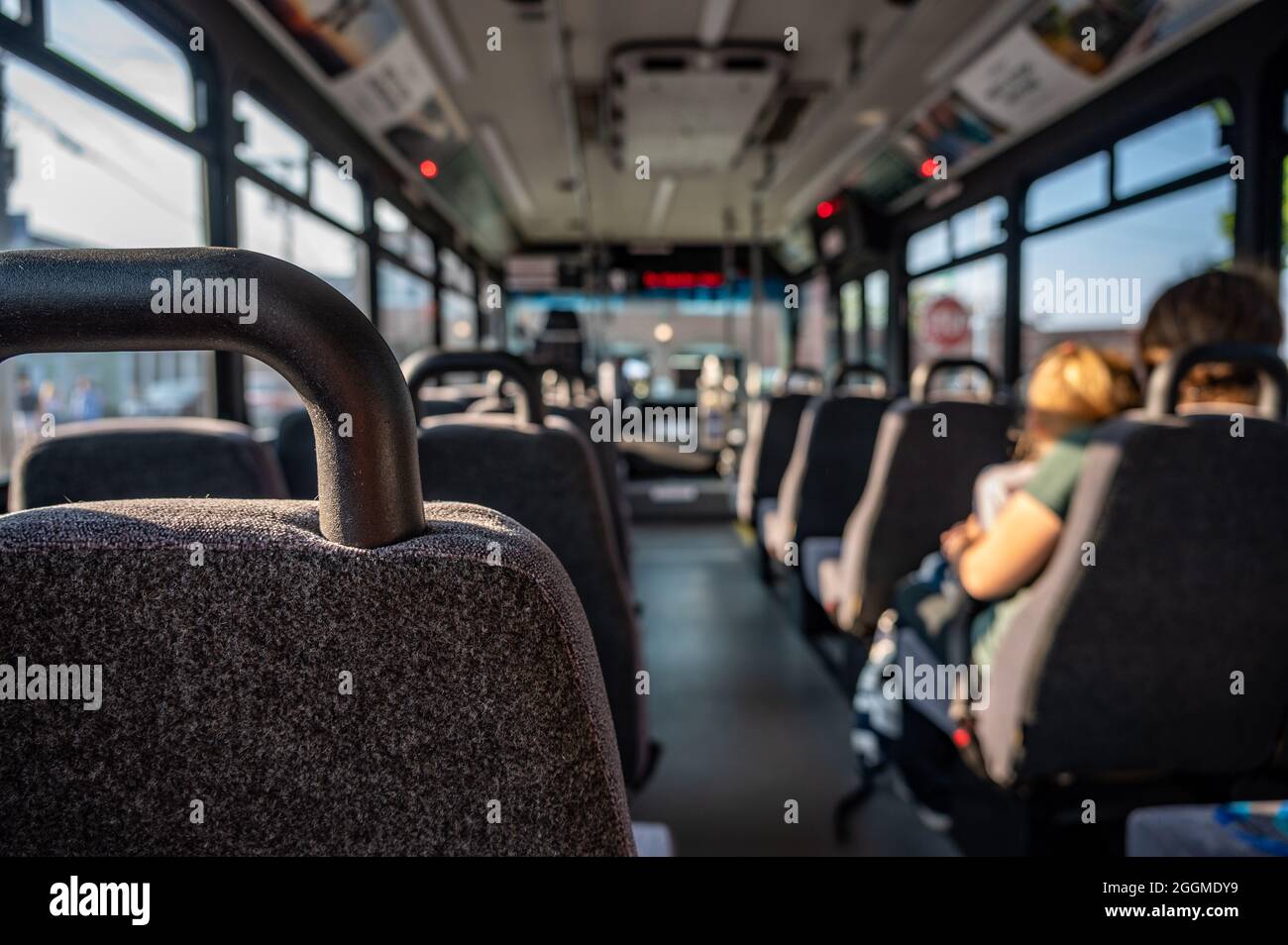 Focus on an empty seat in a bus with only a single mother and child in ...