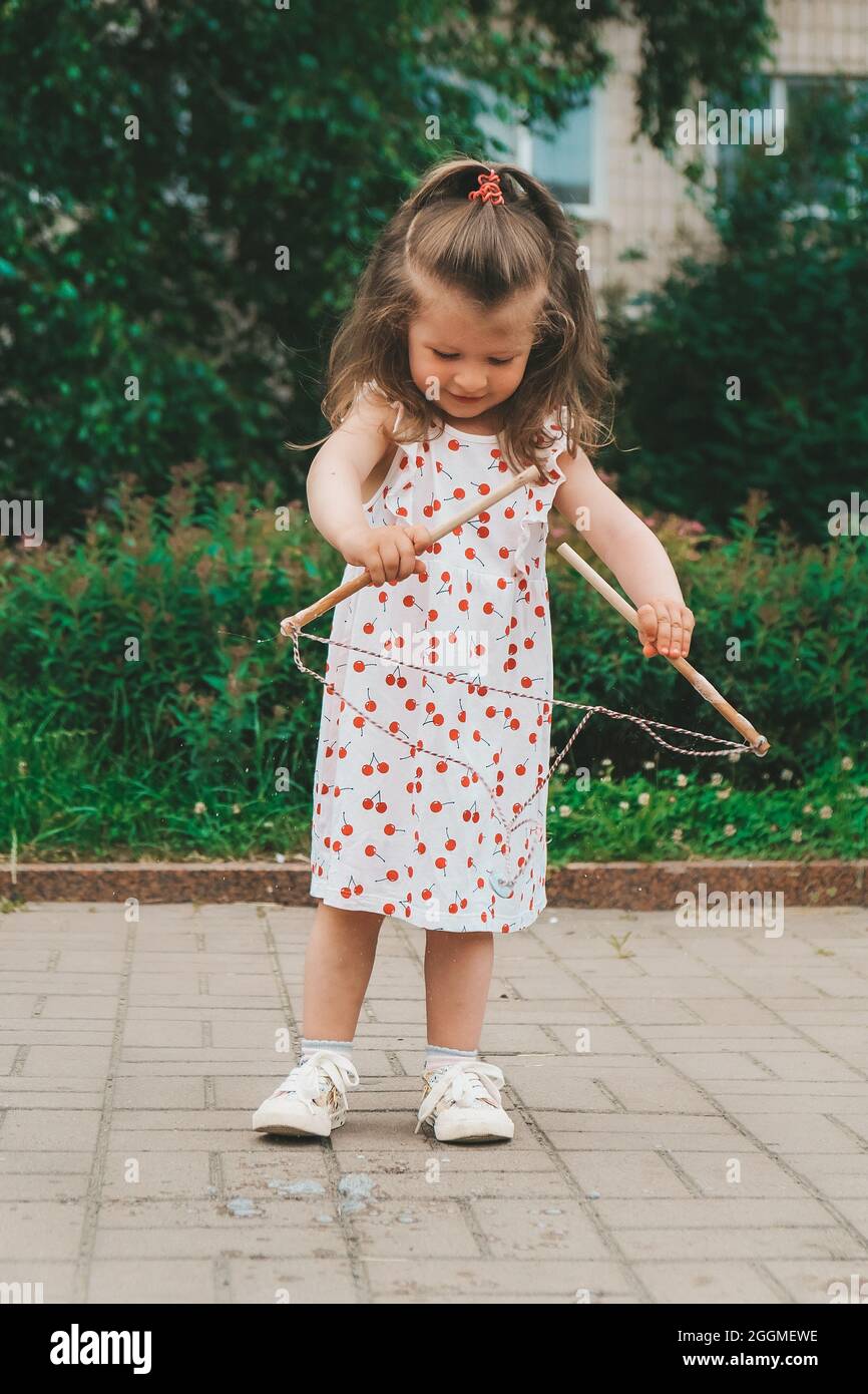 A cheerful girl catches soap bubbles with her hands and laughs. Happy ...