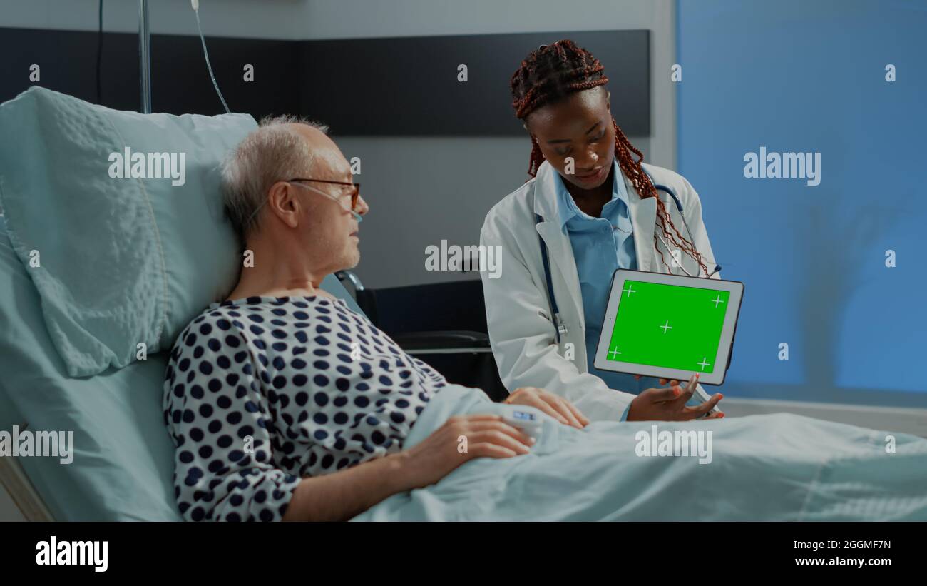 Specialist woman showing green screen on tablet to patient feeling sick ...