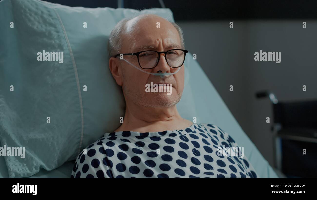 Portrait of ill patient laying in hospital ward at recovery unit with ...