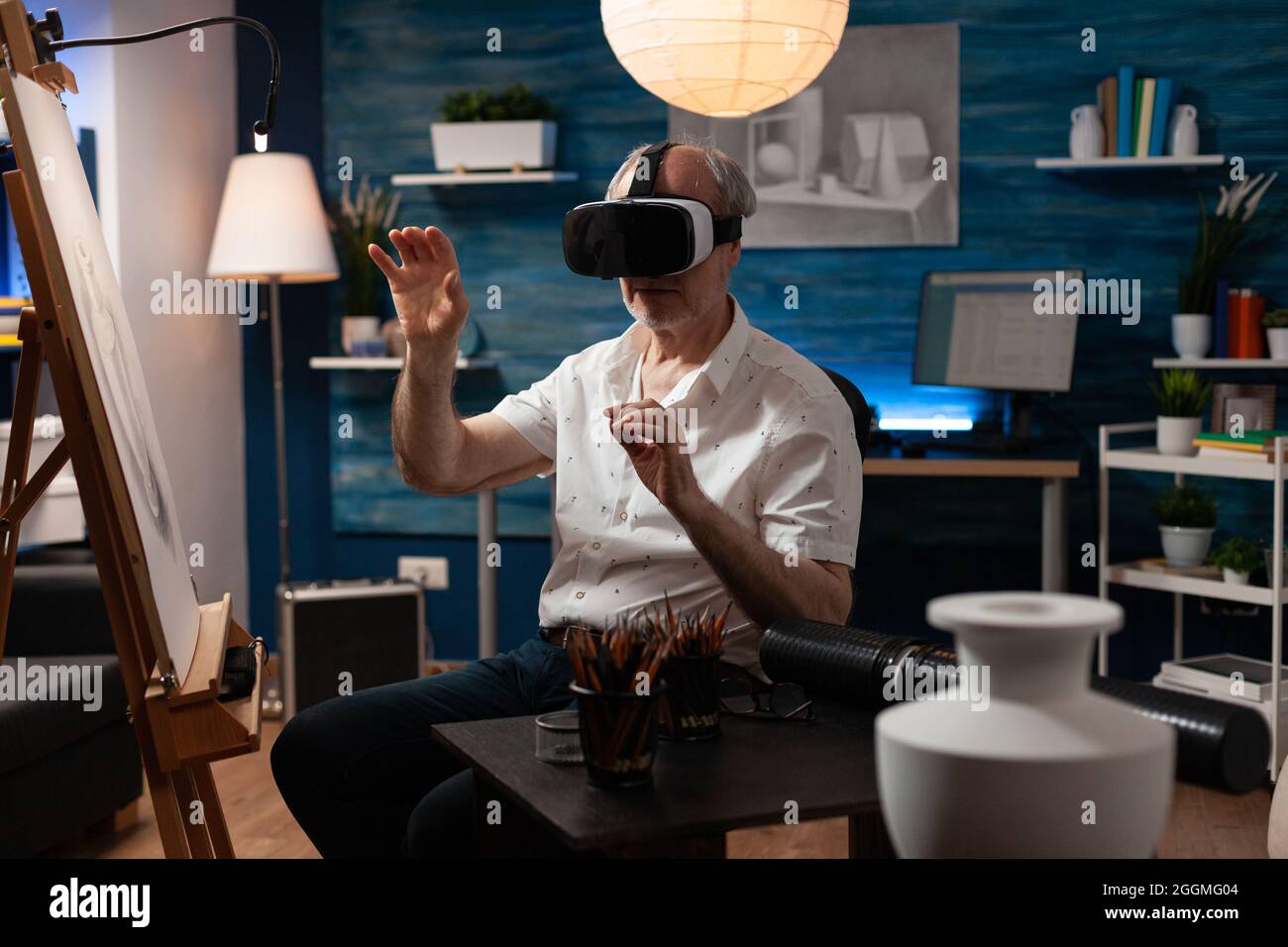Senior artist using vr glasses for virtual inspiration at art studio ...