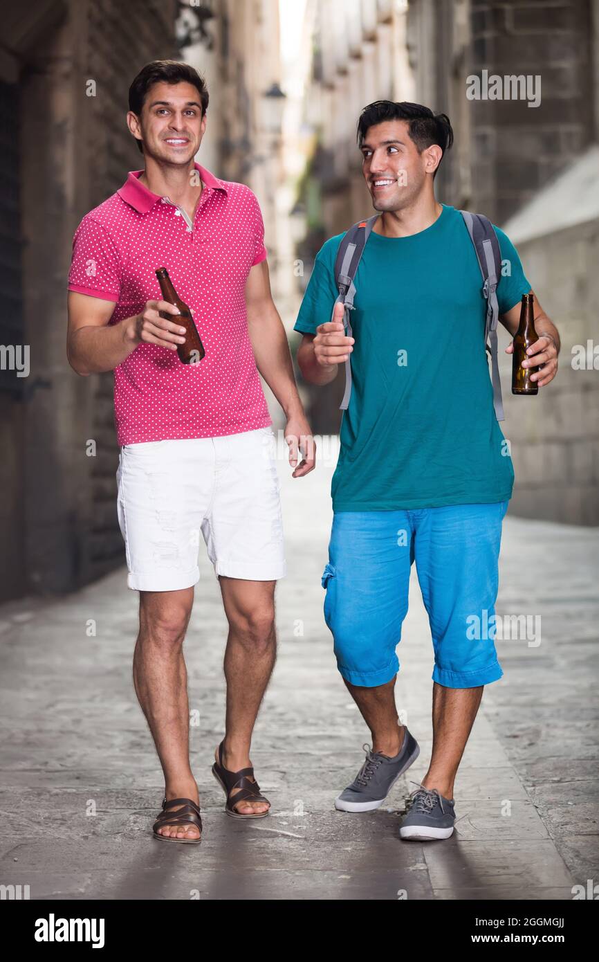 Two guys friends are walking and drinking beer Stock Photo - Alamy