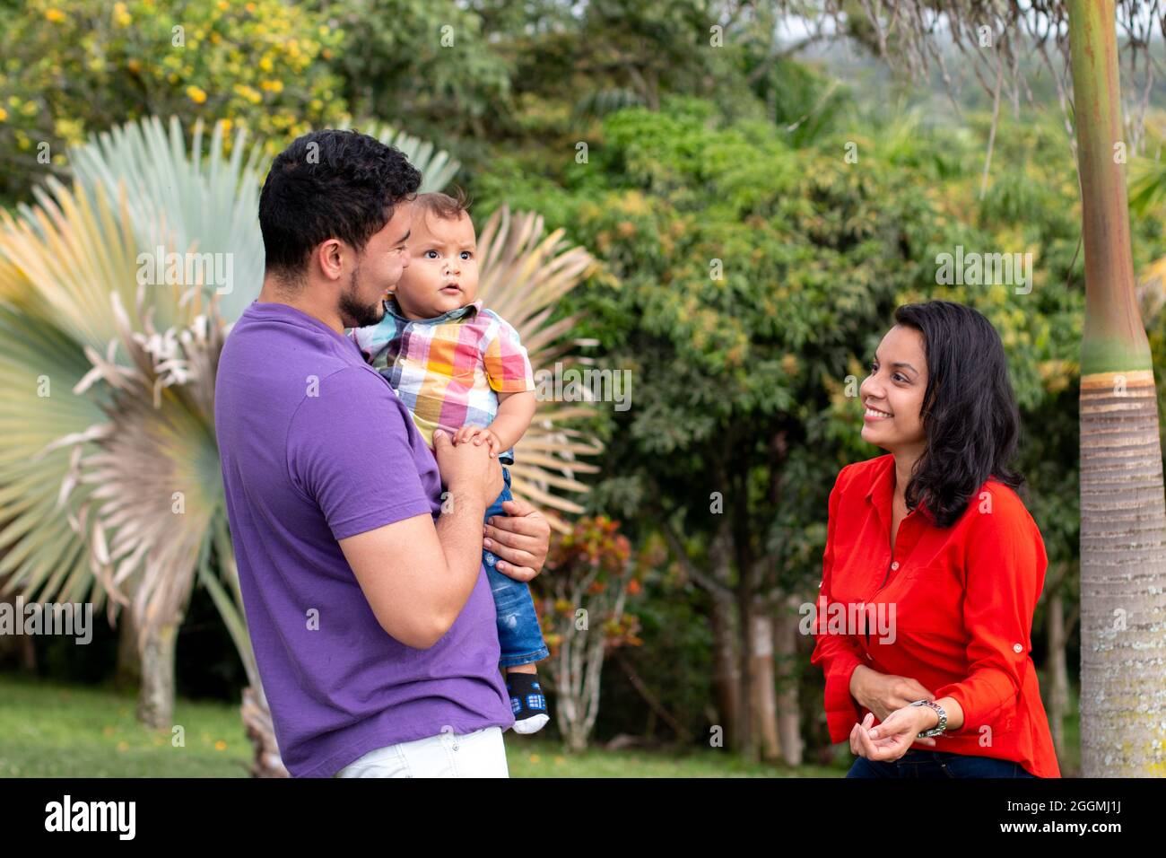 Happy parents taking care of their baby in a beautiful park full of ...