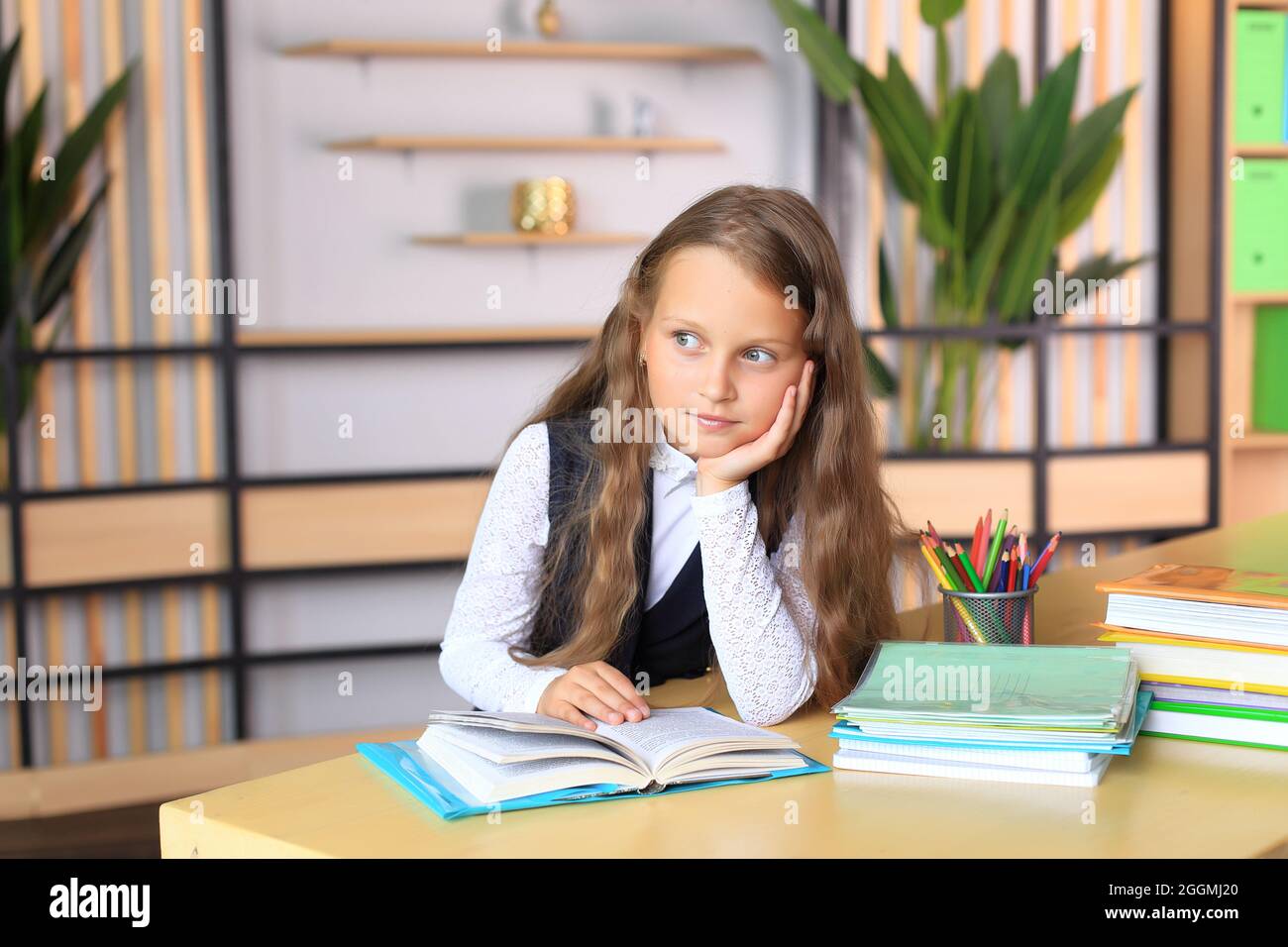 The schoolgirl sits over notebooks. The girl writes in a school ...