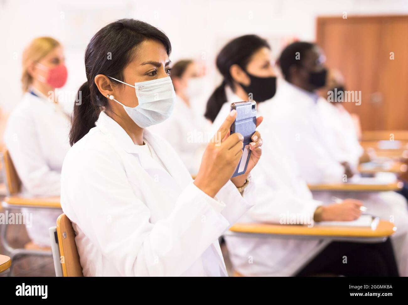 Woman recording lecture on phone at conference Stock Photo - Alamy