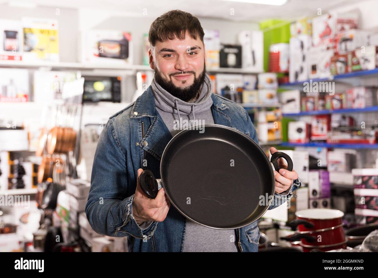 Satisfied man buys new pan in the hardware store Stock Photo - Alamy