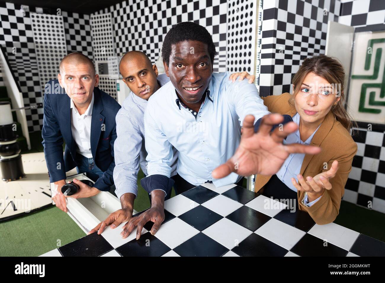 Four friends solving puzzles in quest room Stock Photo - Alamy
