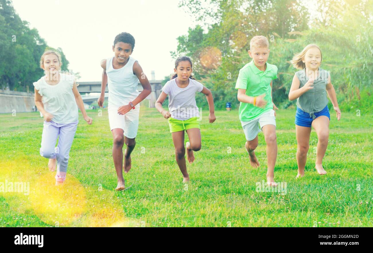 Five smiling kids running and laughing in park Stock Photo - Alamy