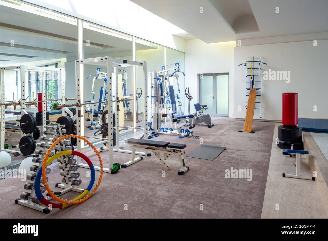 Home gym interior with exercise equipment, dumbbells and boxing bag ...