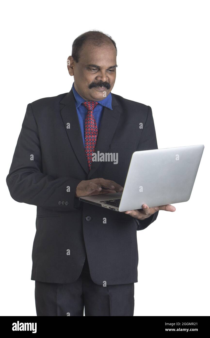 Vertical shot of a man holding a laptop and working on a white ...