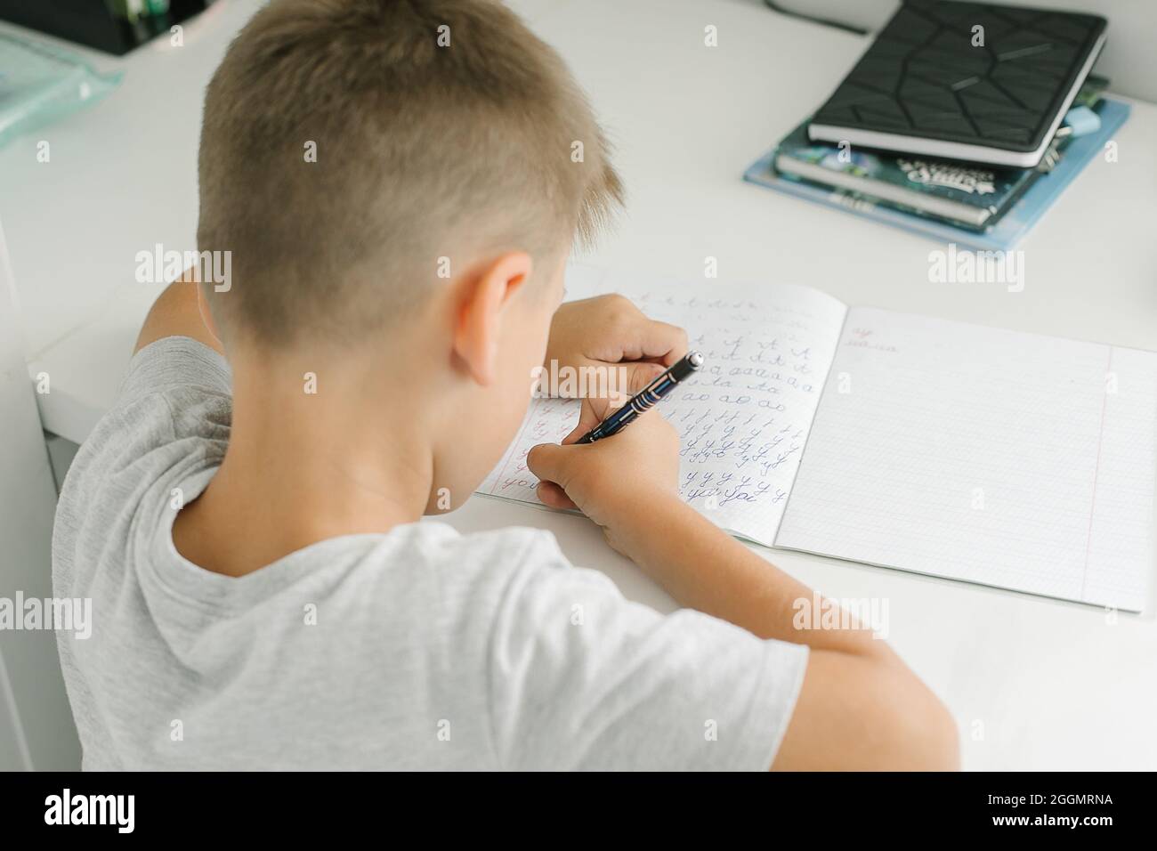 Caucasian schoolboy boy doing school homework. Homeschooling concept ...