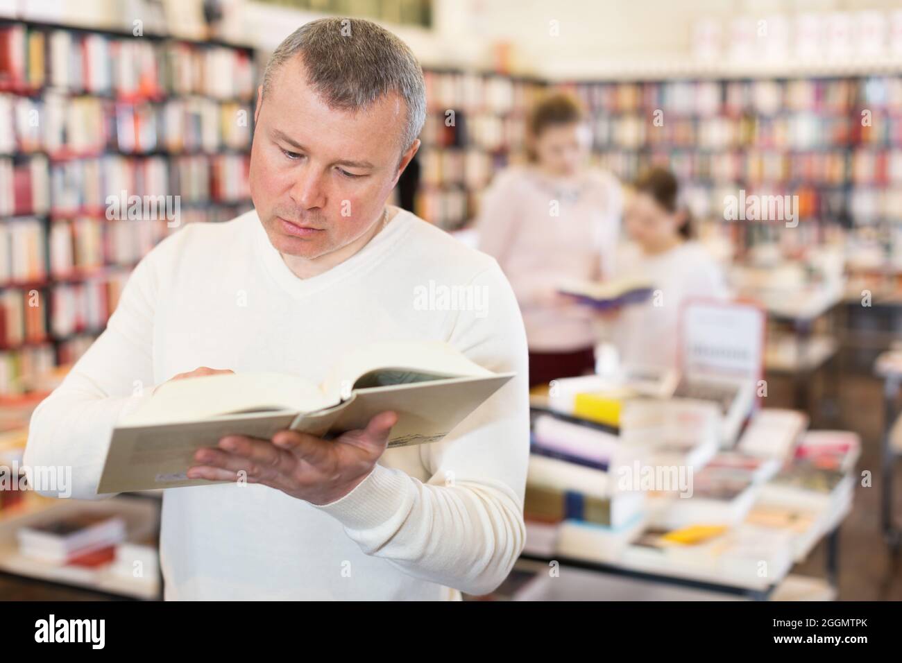 Man browsing inside of books while visiting library Stock Photo - Alamy