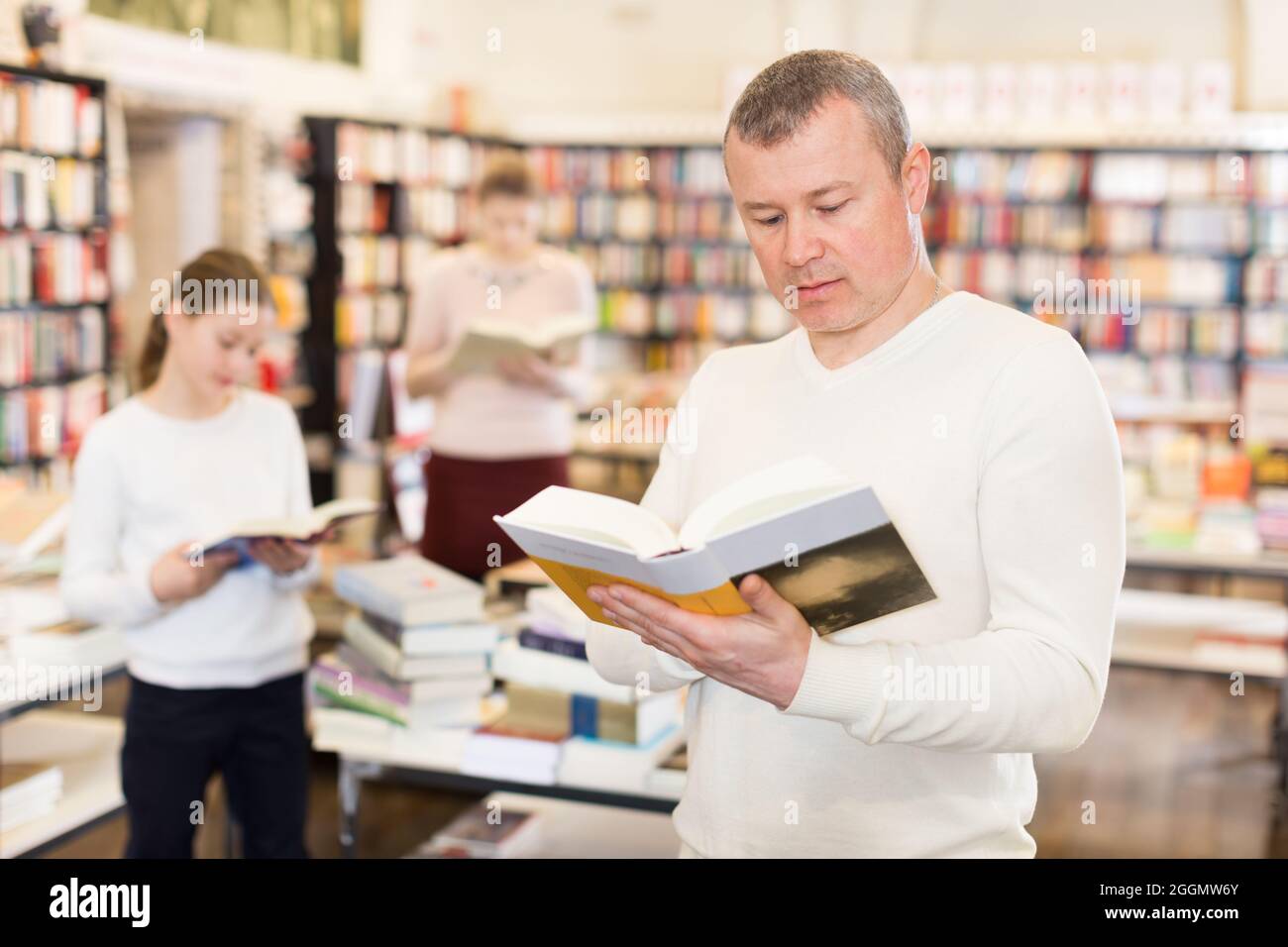 Man browsing inside of books while visiting library Stock Photo - Alamy