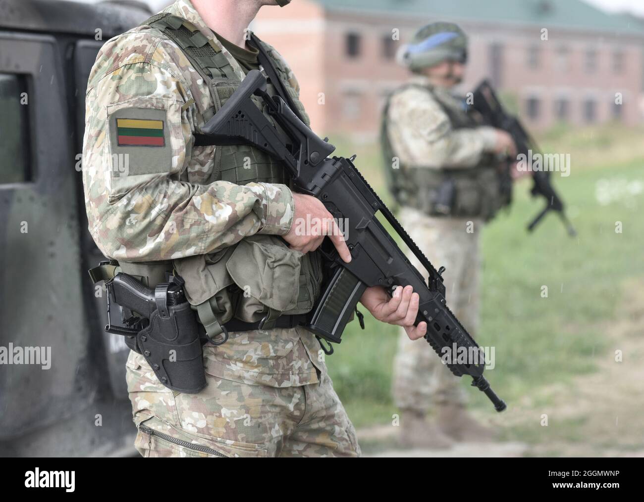 Soldiers with assault rifle and flag of Lithuania on military uniform ...