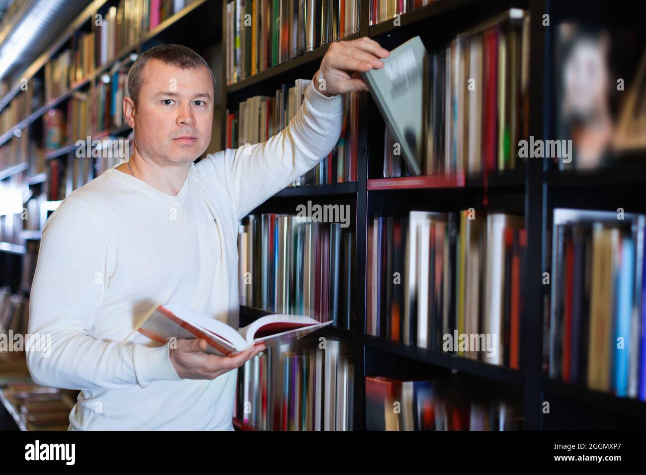 Young guy choosing books read hi-res stock photography and images - Alamy