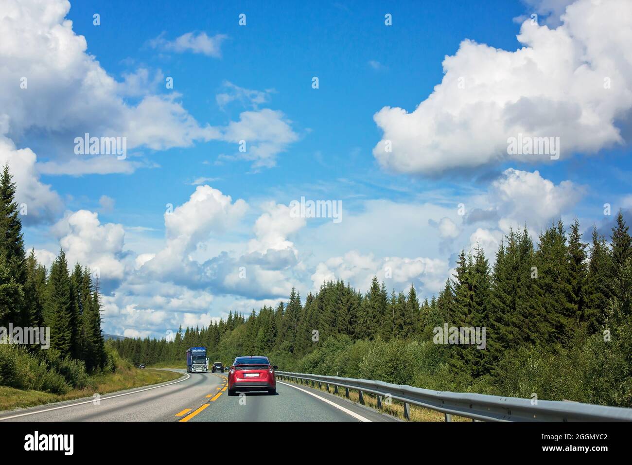 Road with trees, cars and cloudy sky in Norway, summertime Stock Photo ...