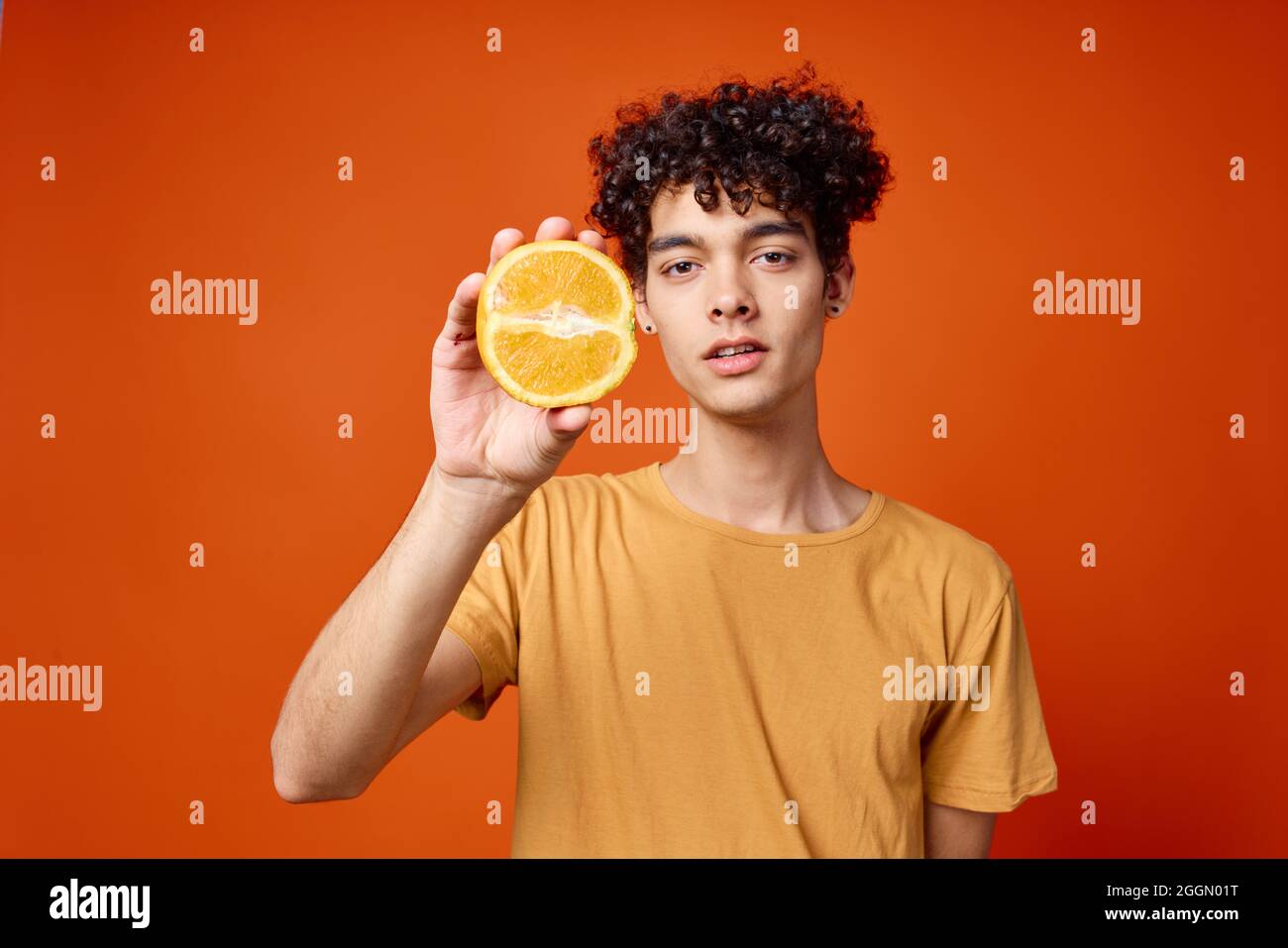 Cheerful curly guy with oranges in his hands fruits lifestyle Stock ...