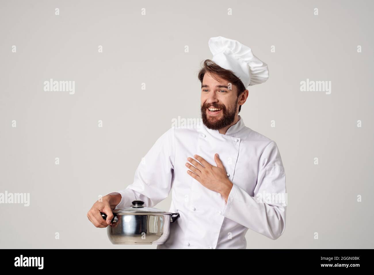 professional chef tastes food with a pan in his hands restaurant light ...