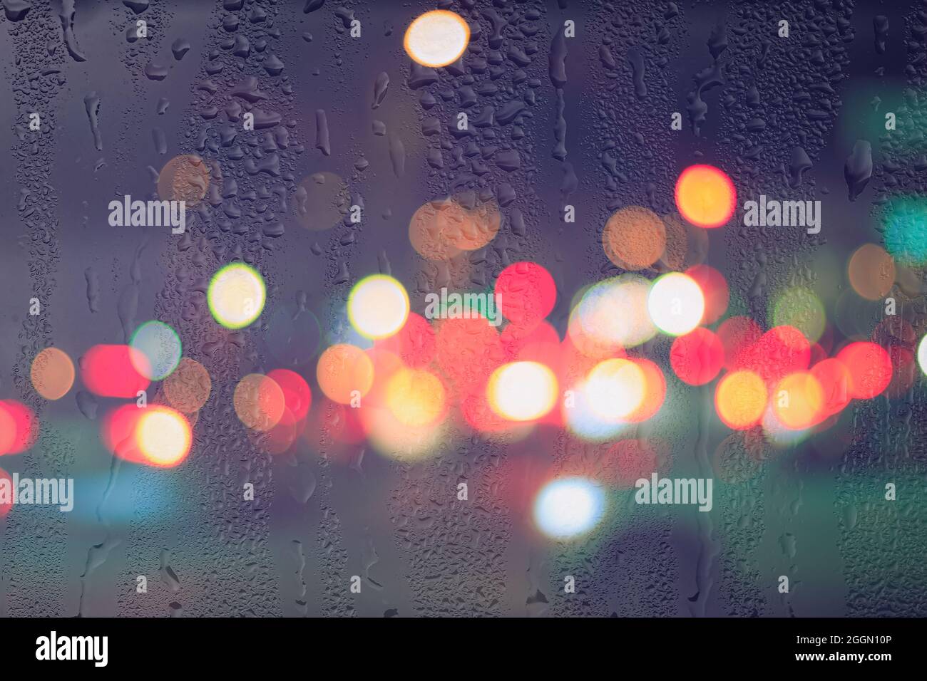 Night city lights and car headlights through rainy glass. Rain and bad ...