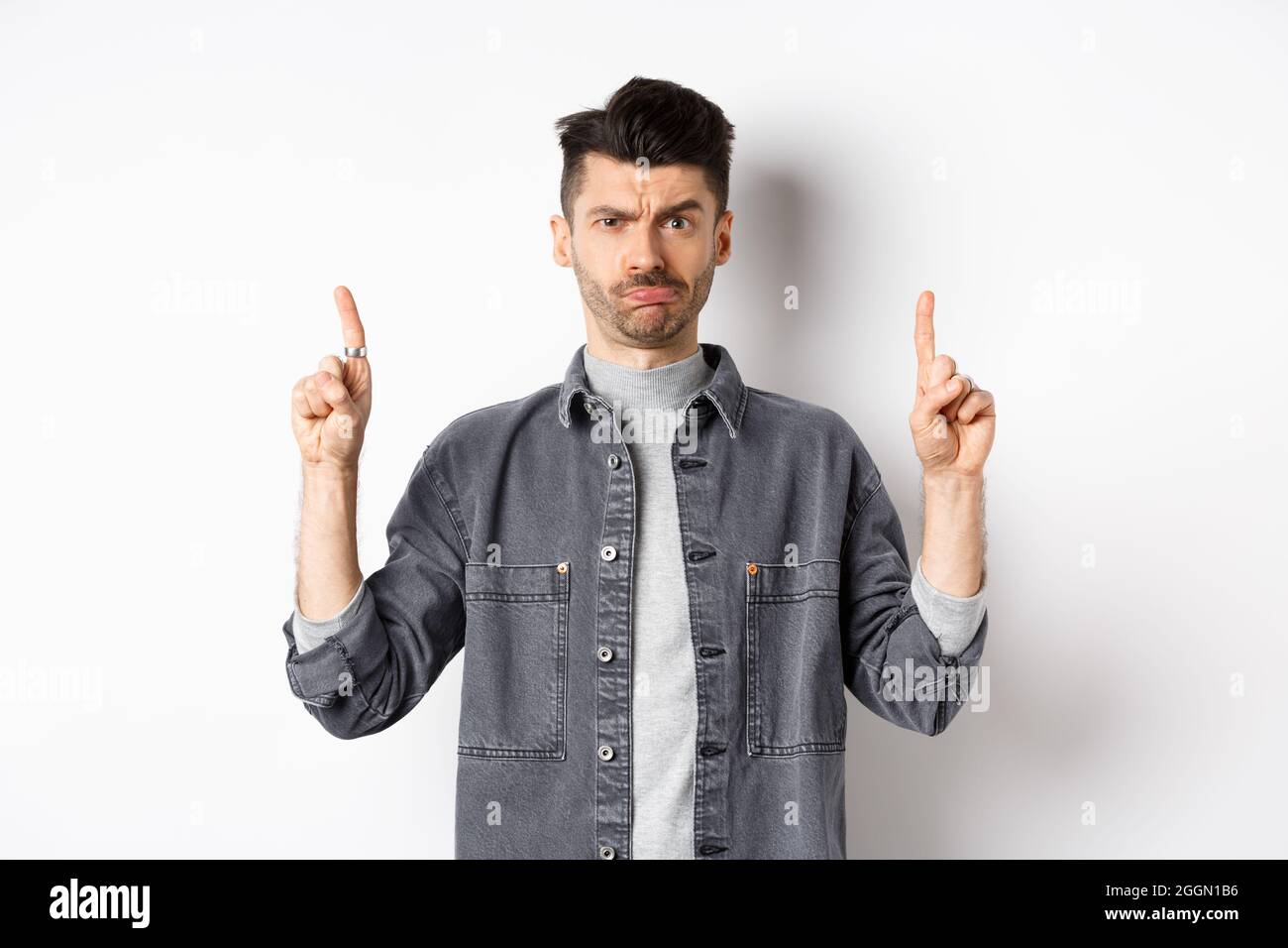 Confused funny guy with moustache pointing fingers up at something ...