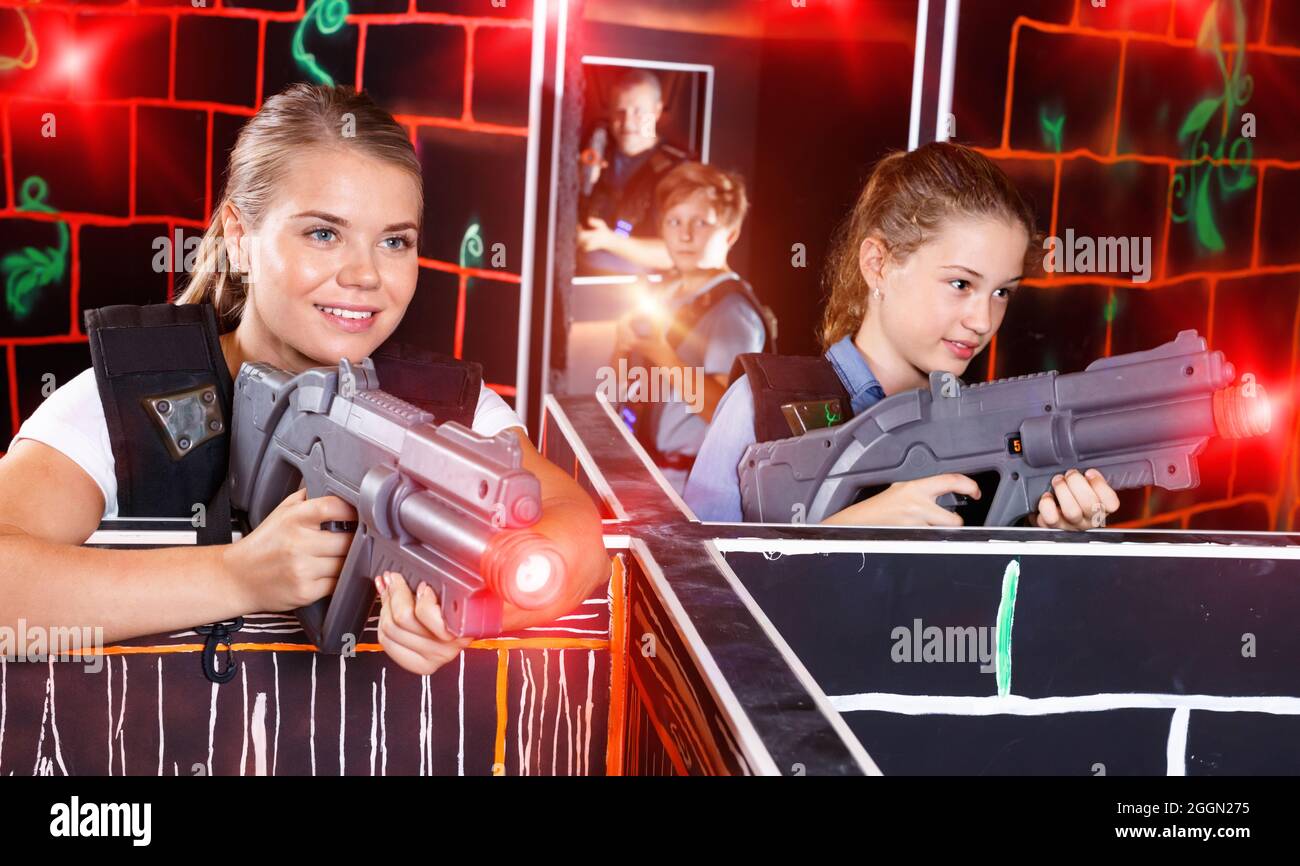 Modern young woman and teen girl with laser pistols playing lase Stock ...