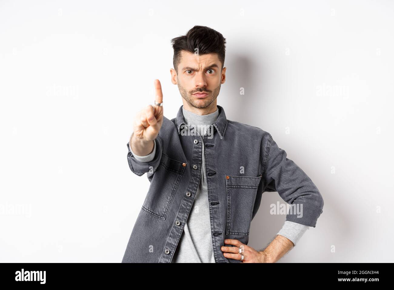 Stop right here. Serious man scolding, shaking finger and frowning ...