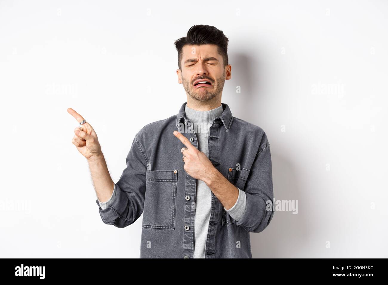 Sad crying man pointing fingers left at logo, sobbing and whining ...