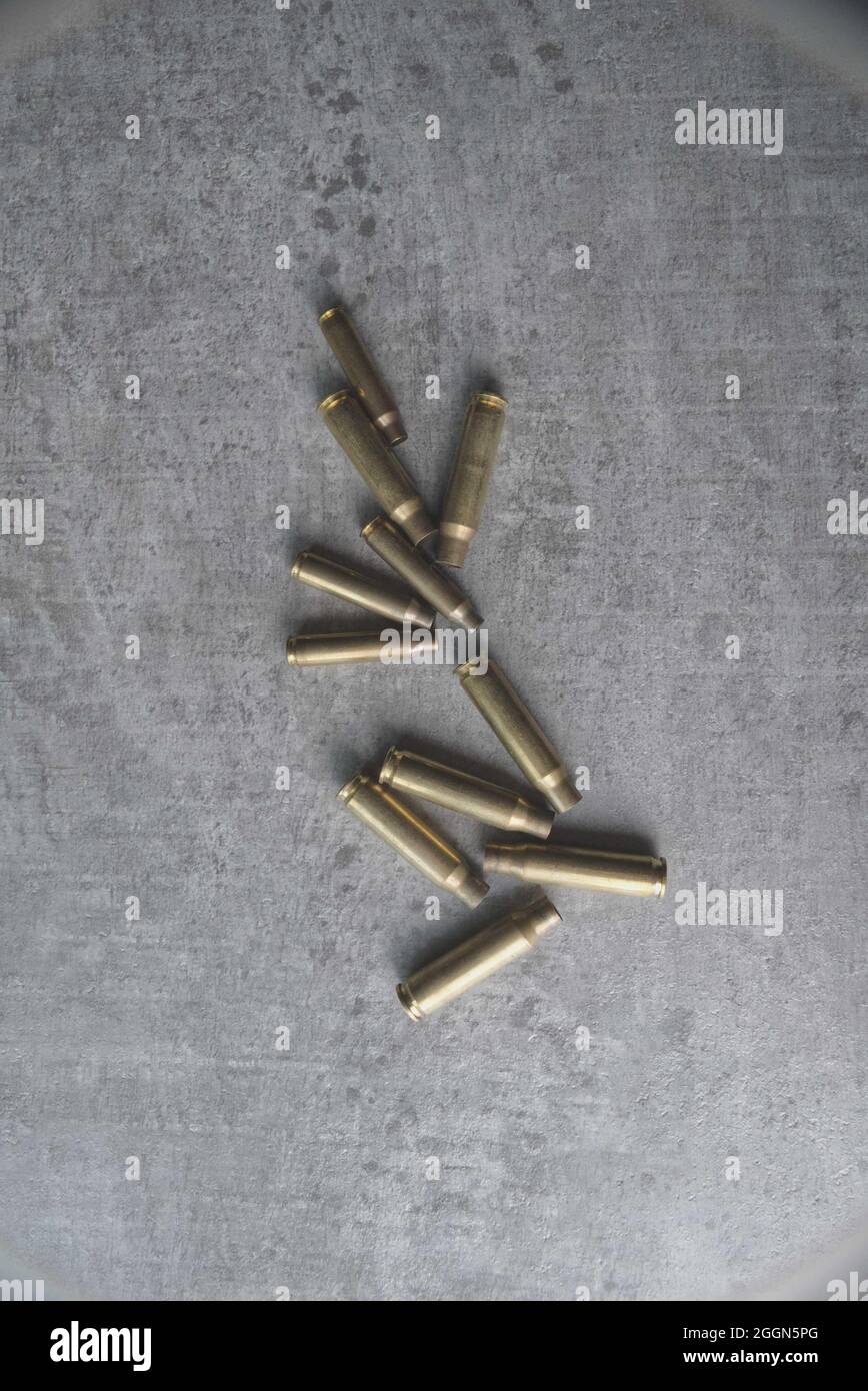 mix of brass used shell cases small calibre pistol bullets on grey ...