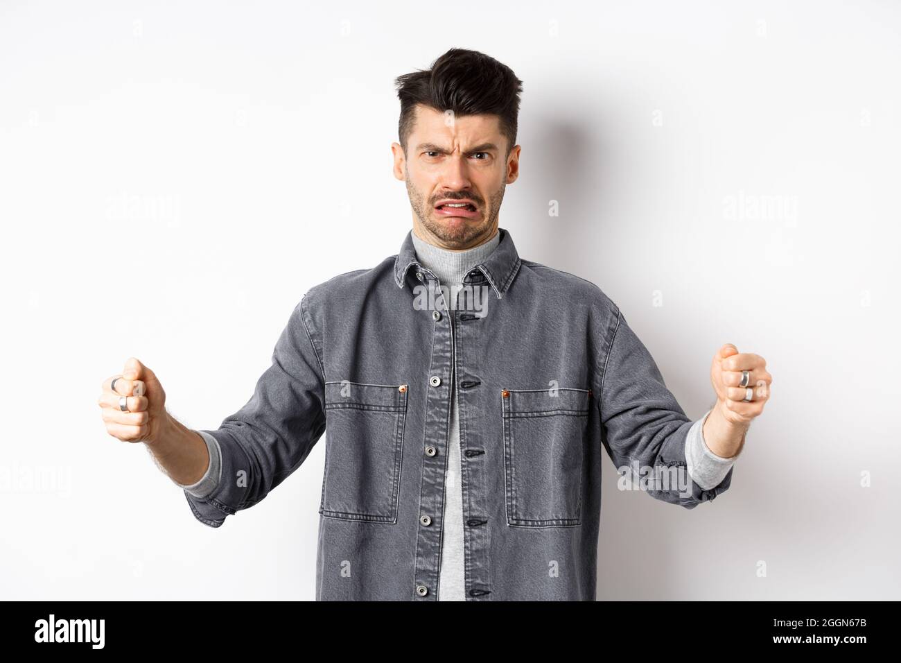 Disgusted guy showing big size object and grimacing from dislike and ...