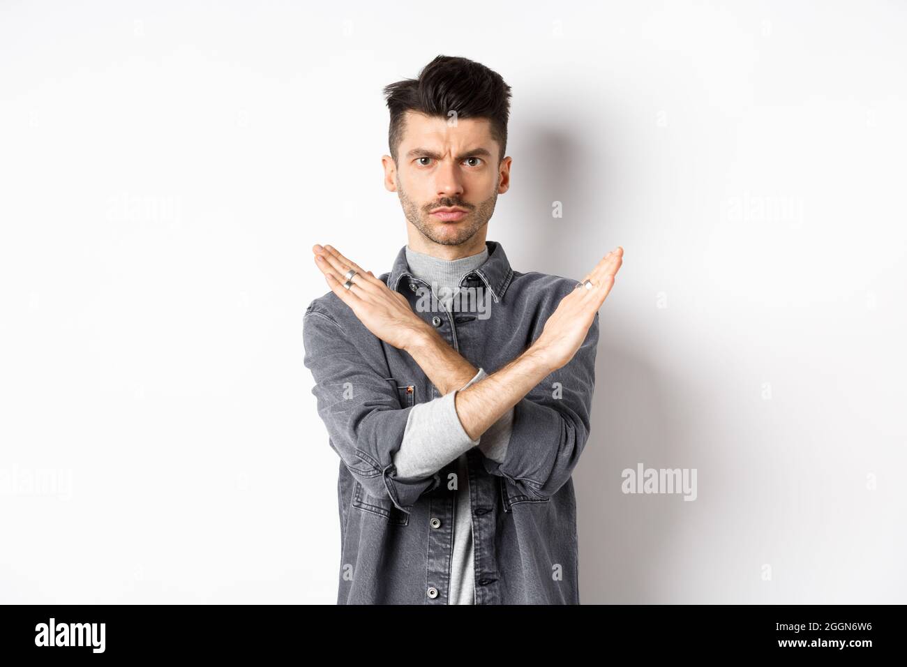 Angry man show cross gesture to stop or say no, frowning and looking ...