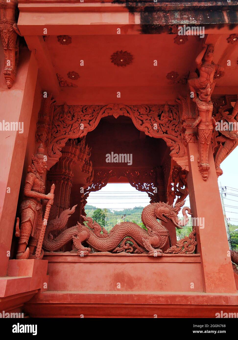 Temple of red color in Thailand. The facade of the temple is decorated ...